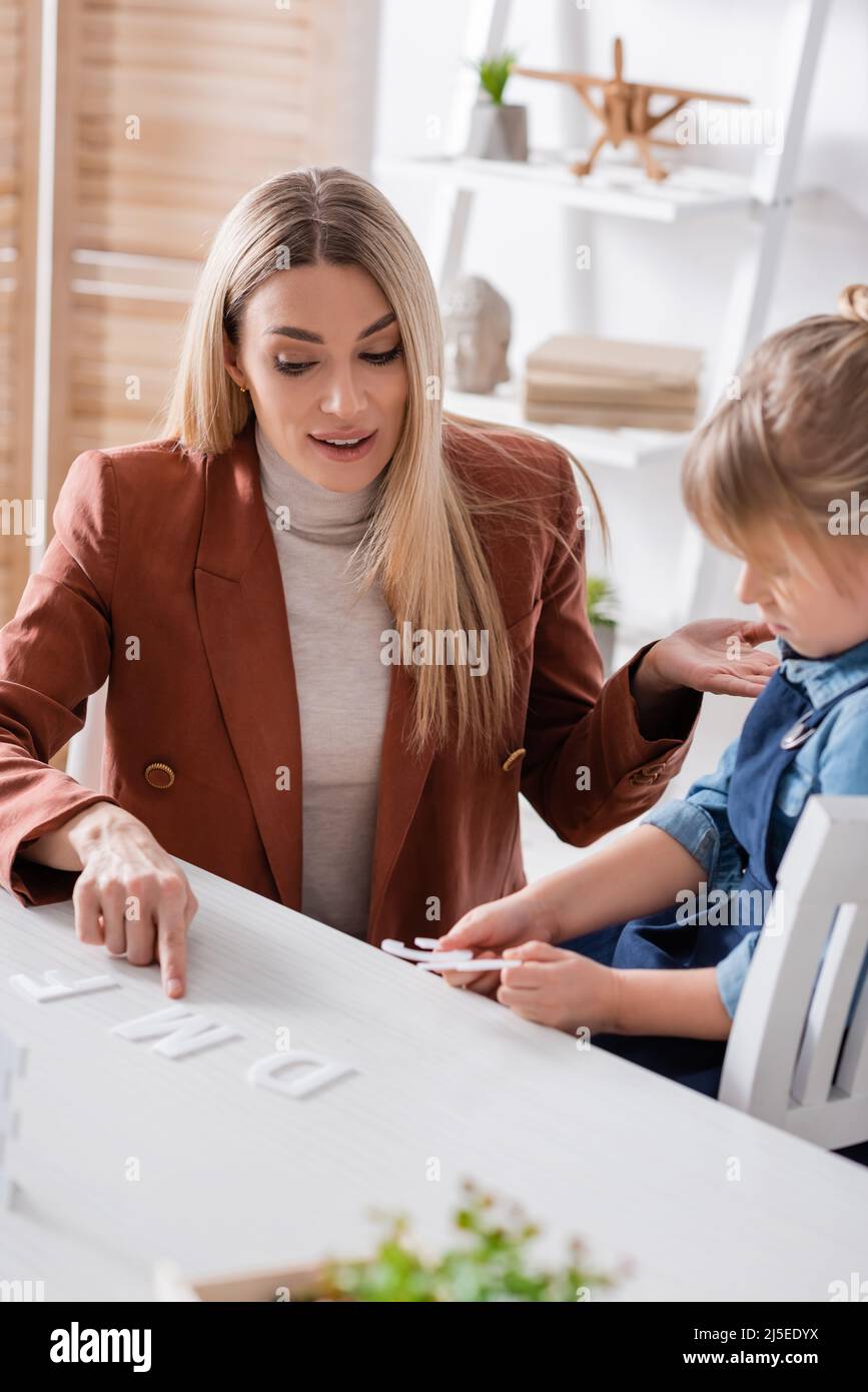 Teacher pointing to letter in classroom hi-res stock photography and ...