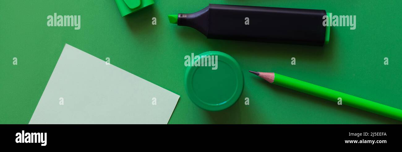 top view of pencil, crayon, jar with paint and marker pen near paper ...