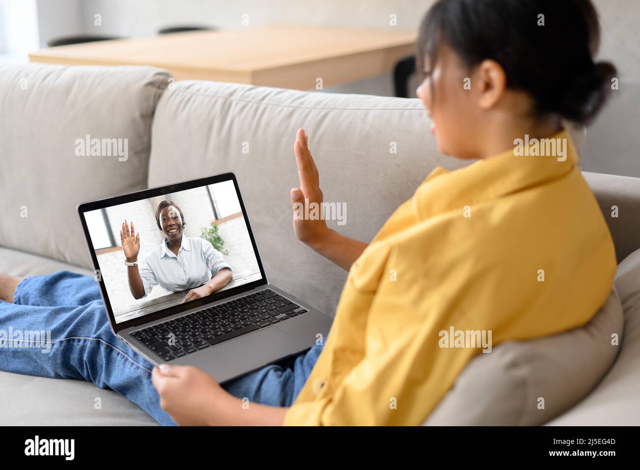 Virtual conference, webinar. Young multiracial woman waves hello to her ...