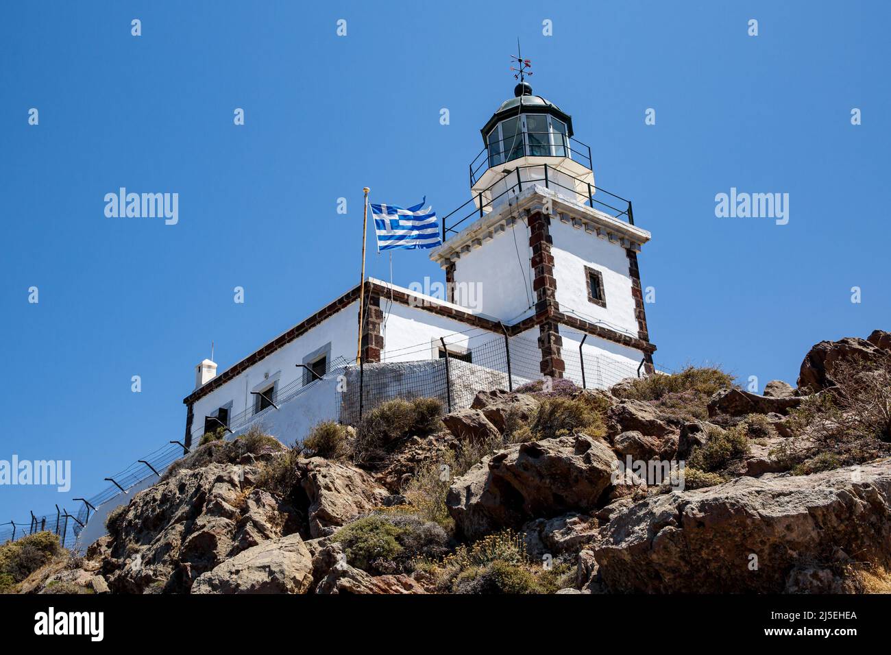 Old lighthouse with Greece flag on blue sky background Stock Photo - Alamy