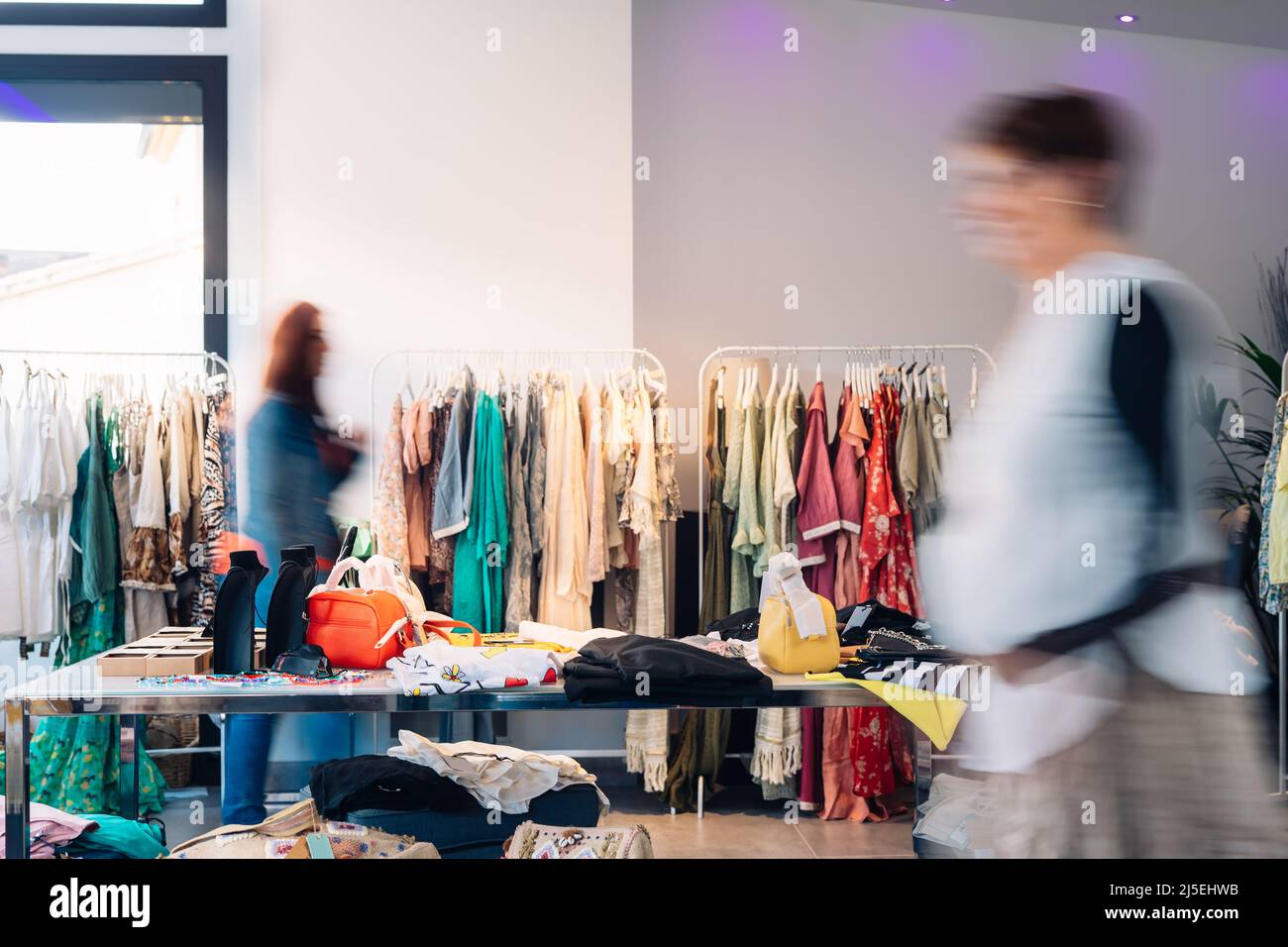 out of focus movement effect of two customers in a fashion shop ...