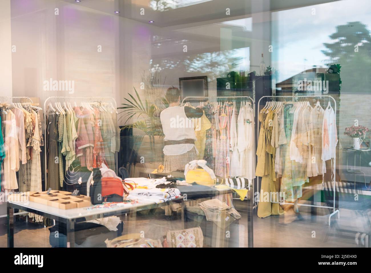 view from the outside of an elderly woman inside a clothing shop ...