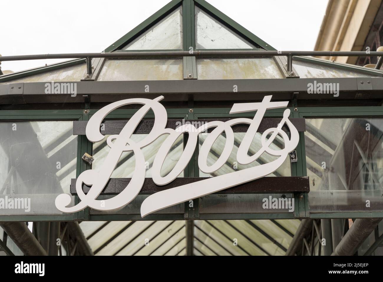Shop logo for high street Pharmacy Boots, white lettering hangs on the ...
