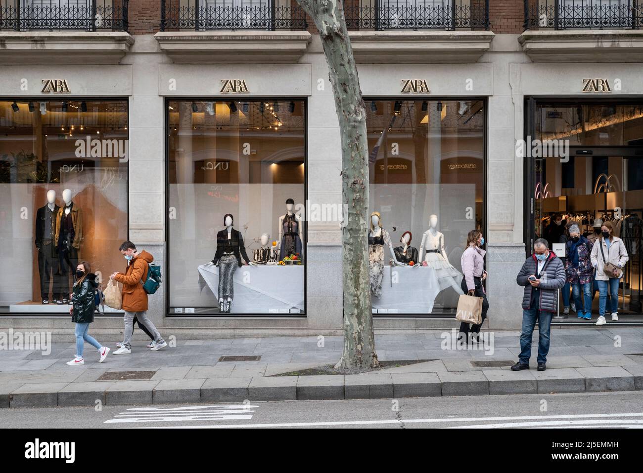 Pedestrians walk past the Spanish multinational clothing design retail ...