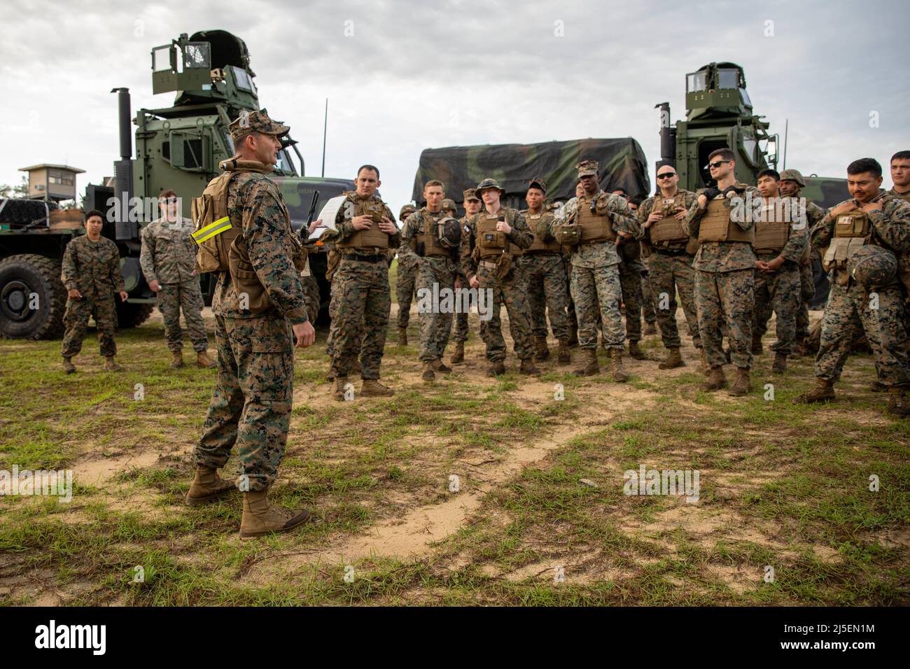 U.S. Marine Corps Staff Sgt. Adam W. Hess, center, range safety officer ...