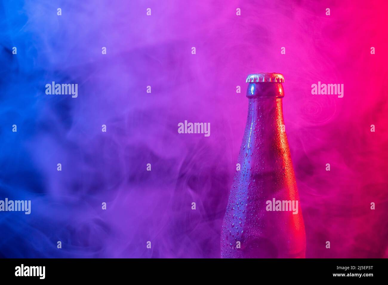Glass bottle of beer in blue pink mist Stock Photo - Alamy