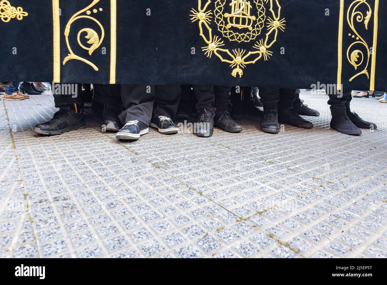 feet of the costalero bearers with black shoes and under the platform ...