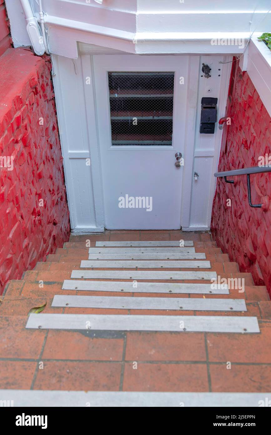 Outdoor basement entrance in the middle of red concrete walls at San ...