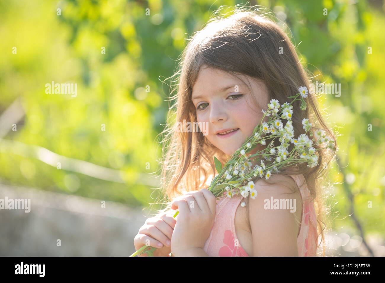 Cute little child girl picking flowers in blooming summer garden ...