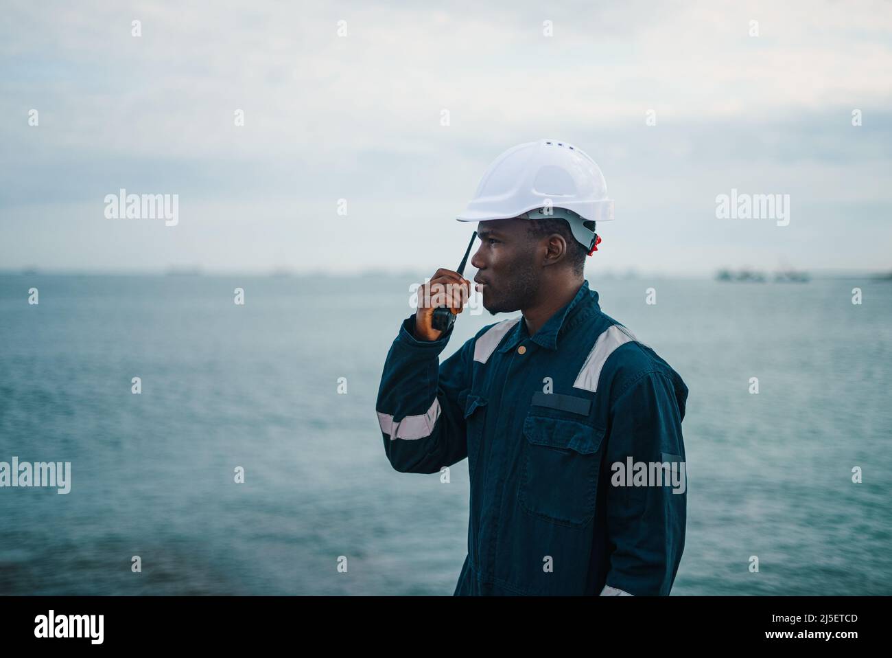 Seaman has communication with VHF handheld radio Stock Photo - Alamy