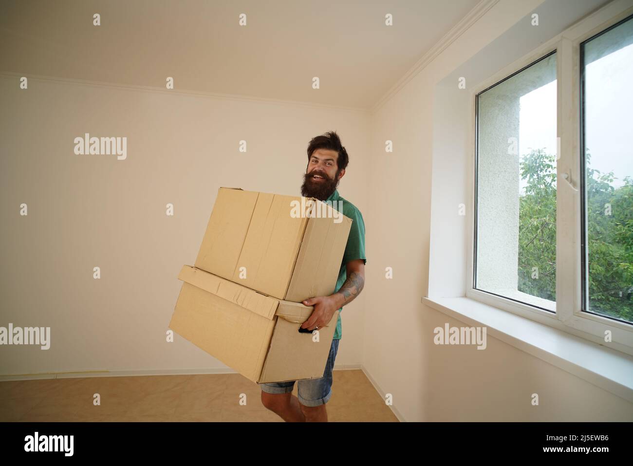 Funny man is carrying his stuff in boxes. Moving to a new apartment ...