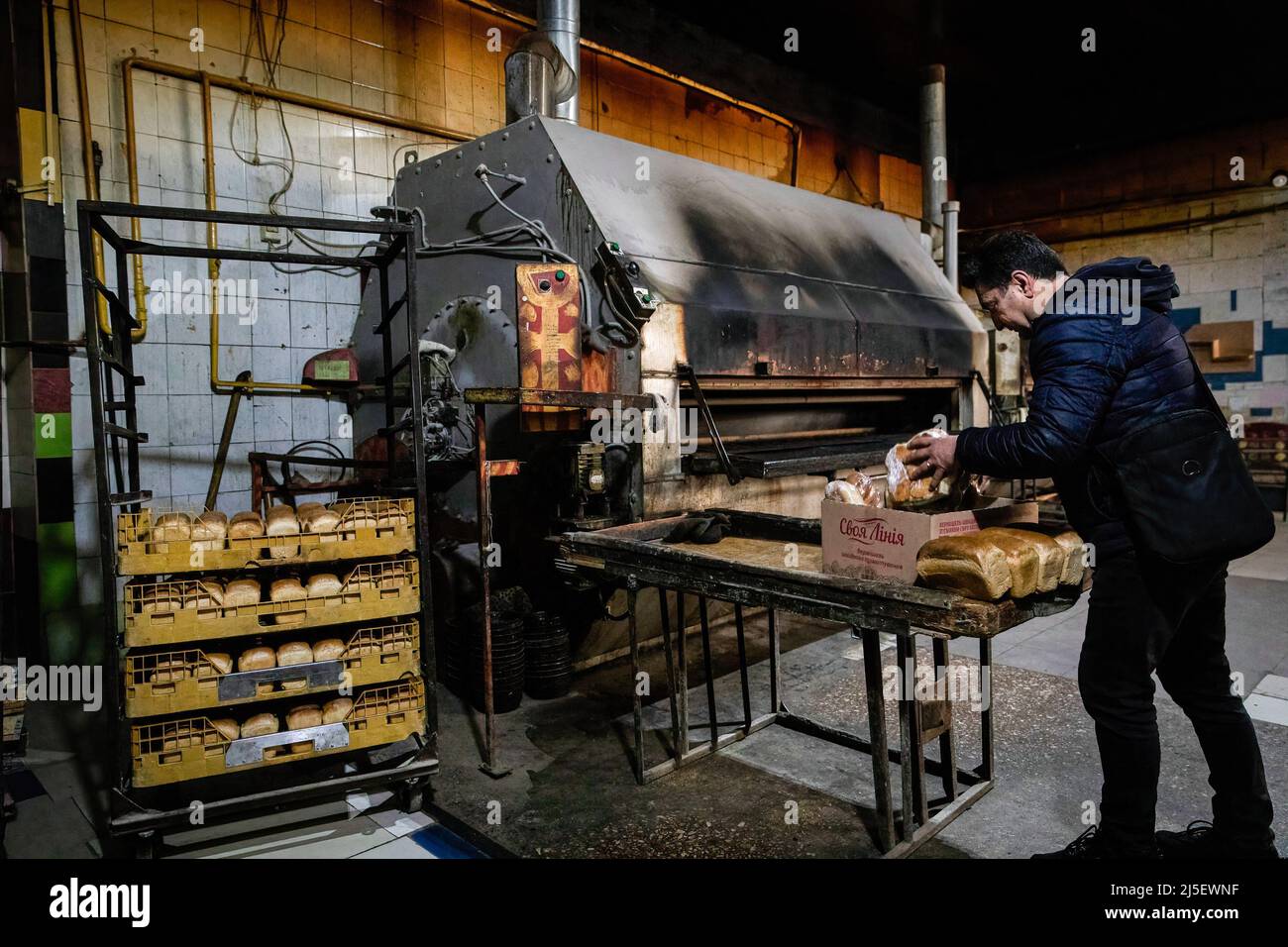 A volunteer packing bread for food distribution in a USSR built bread ...