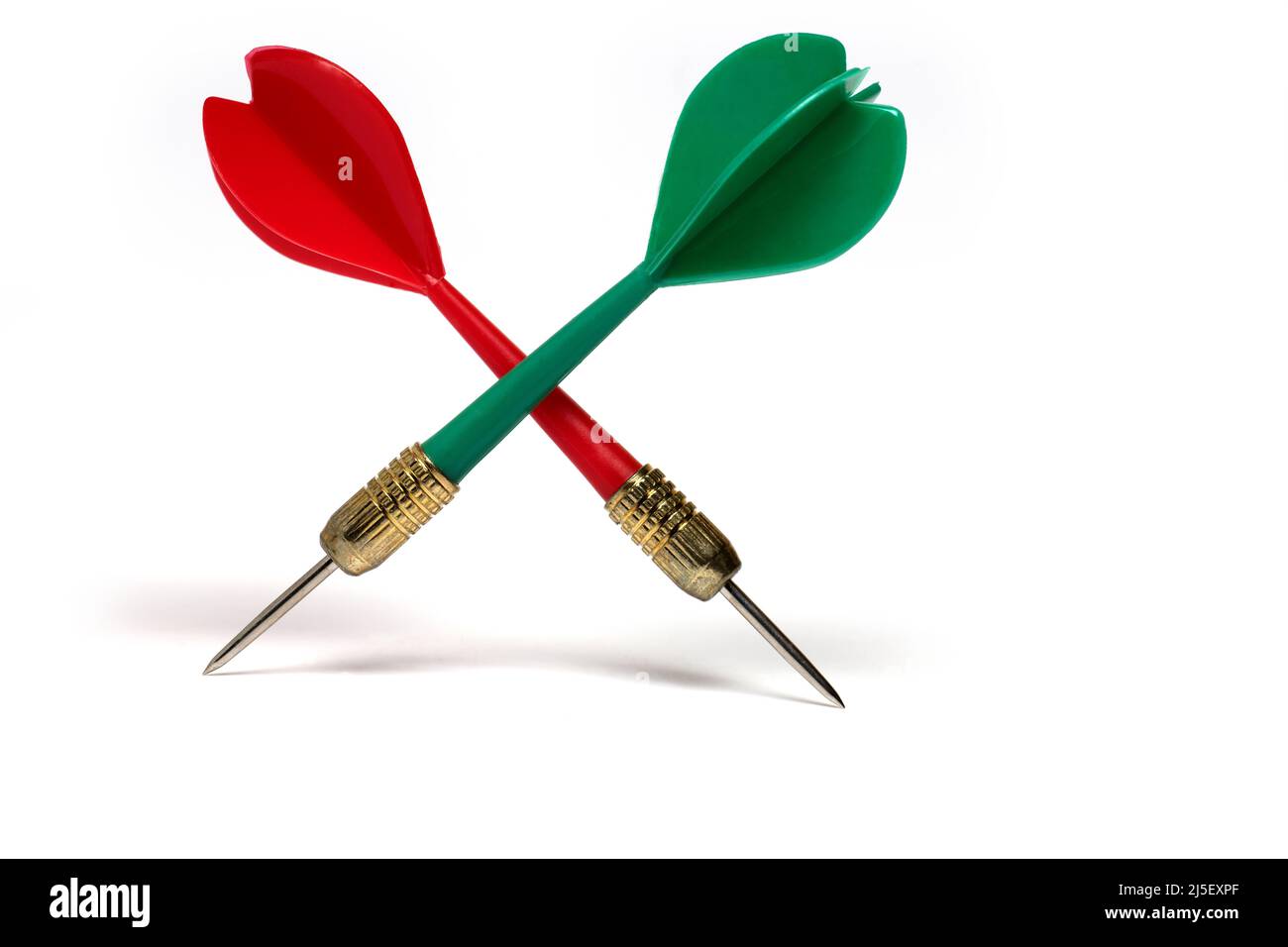 Close up of one red and green dart with pointed metal tip crossed in ...