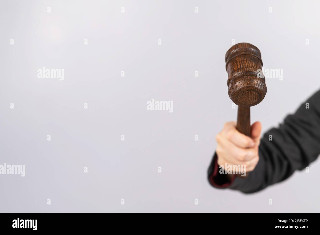 Woman holding judge's gavel on white background Stock Photo - Alamy