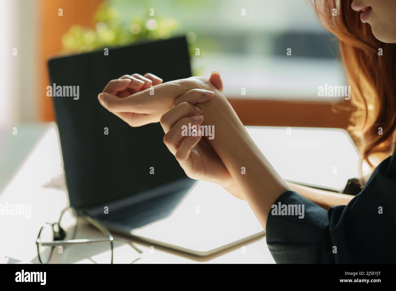 Asian Business woman holding her wrist pain from overworking. Office ...
