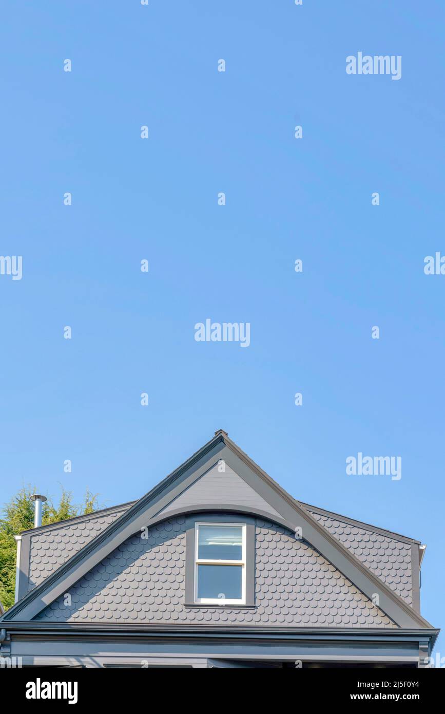 View of a gable roof of a house with gray u-shaped shingle sidings ...