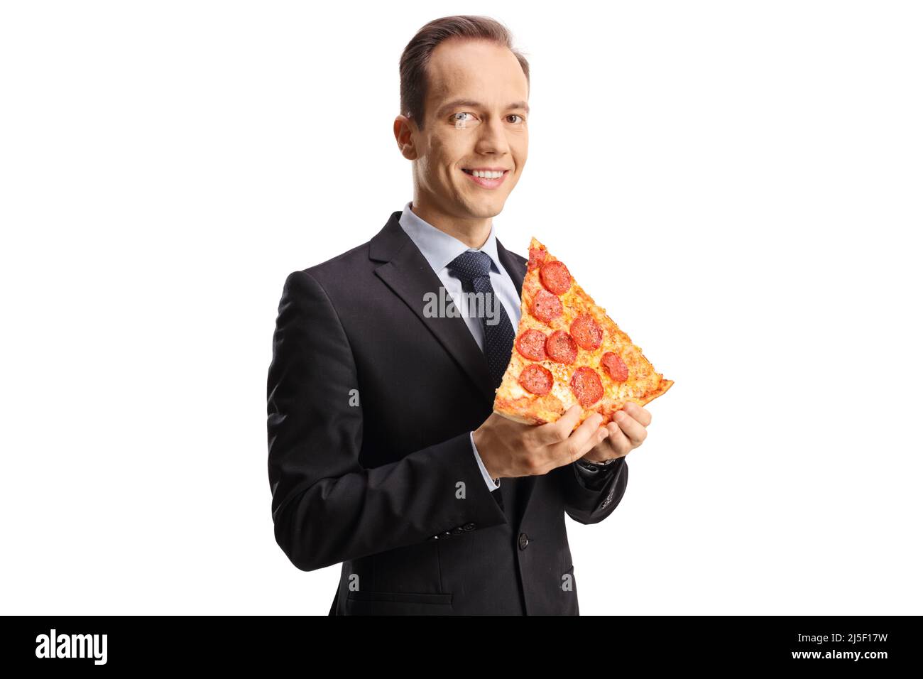 Businessman holding a slice of pepperoni pizza and looking at camera ...