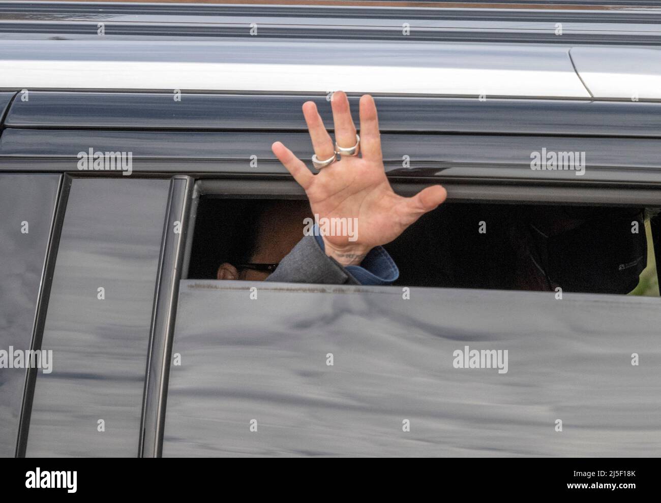 Johnny Depp waves out of his partially open car window as he arrives ...