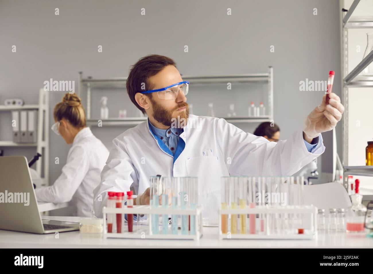 Doctor scientist in laboratory studies blood test for presence of ...