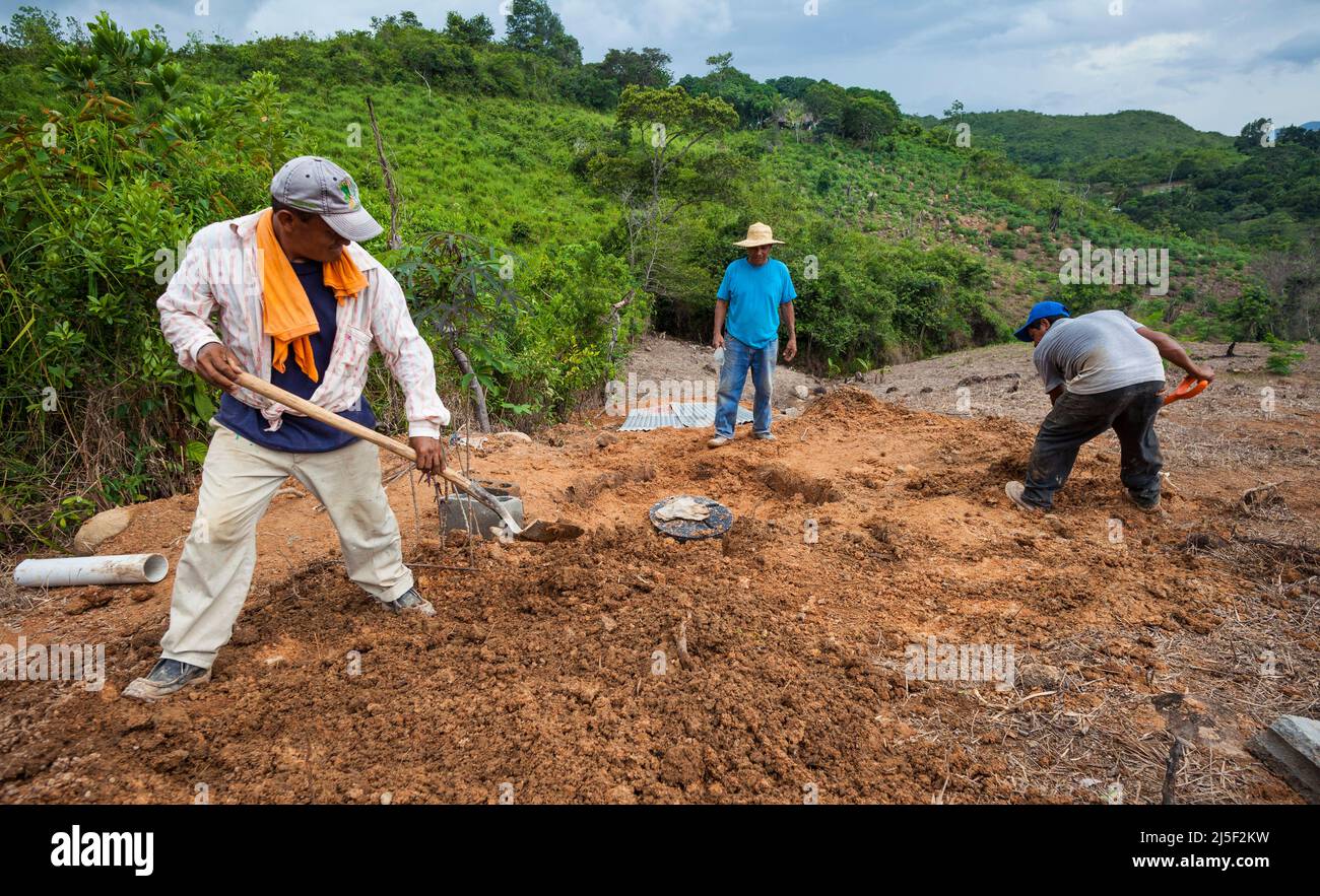 Construction workers are filling earth over a septic tank in Las Minas ...