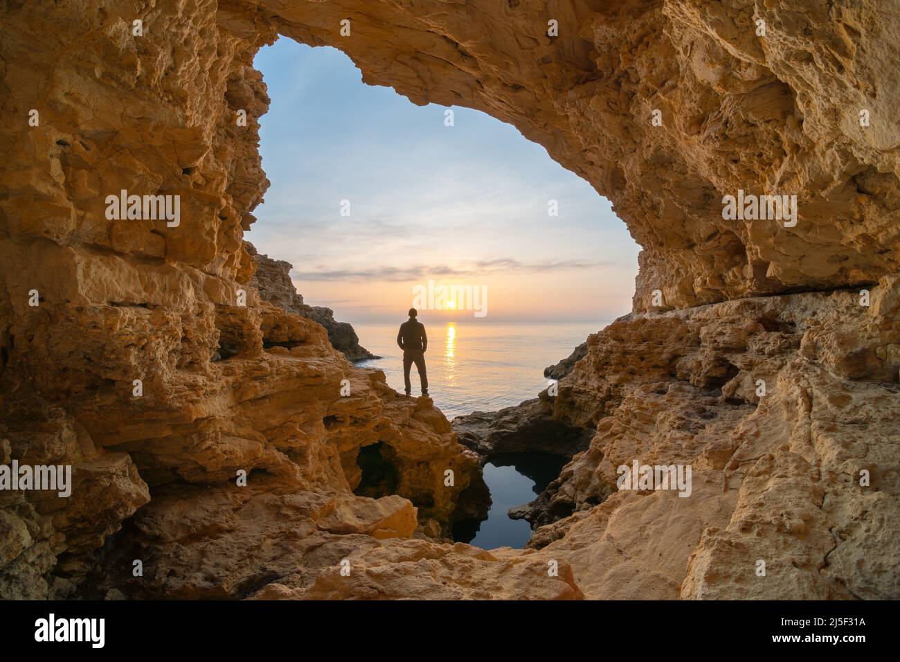 Man in sea grotto. Sea cave mainsail nature landsacpe Stock Photo - Alamy