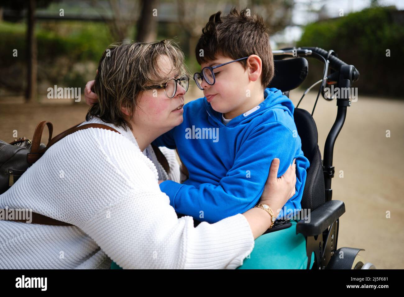 Disabled boy in a wheelchair and his mother enjoying a day together ...