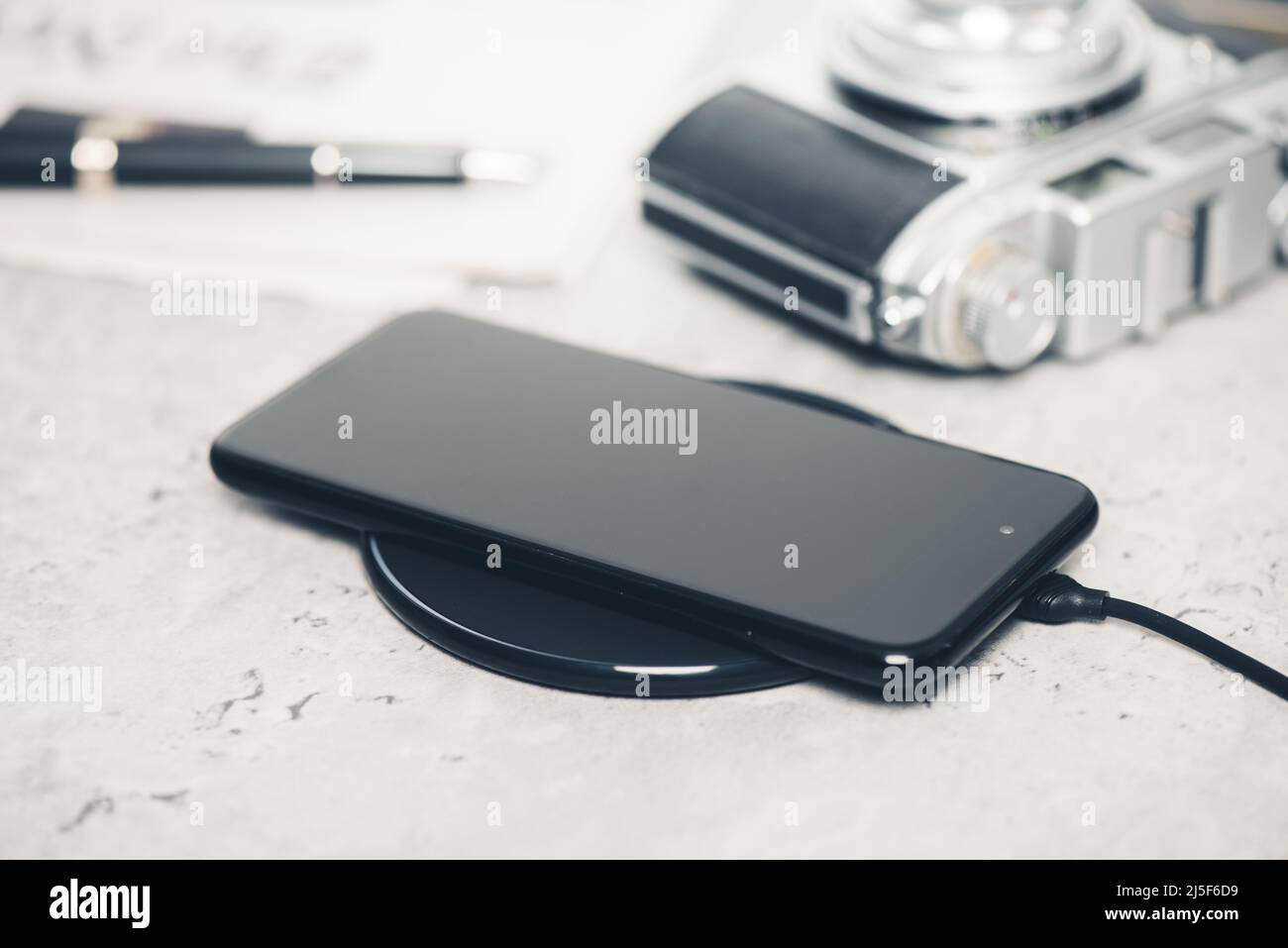 Charging the smartphone with wireless charger on desktop Stock Photo ...