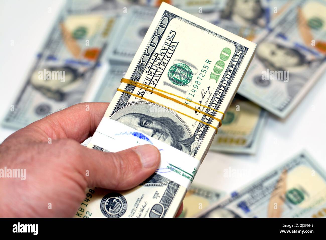 man hand holding a stack of 100 one hundred American dollars banknotes ...