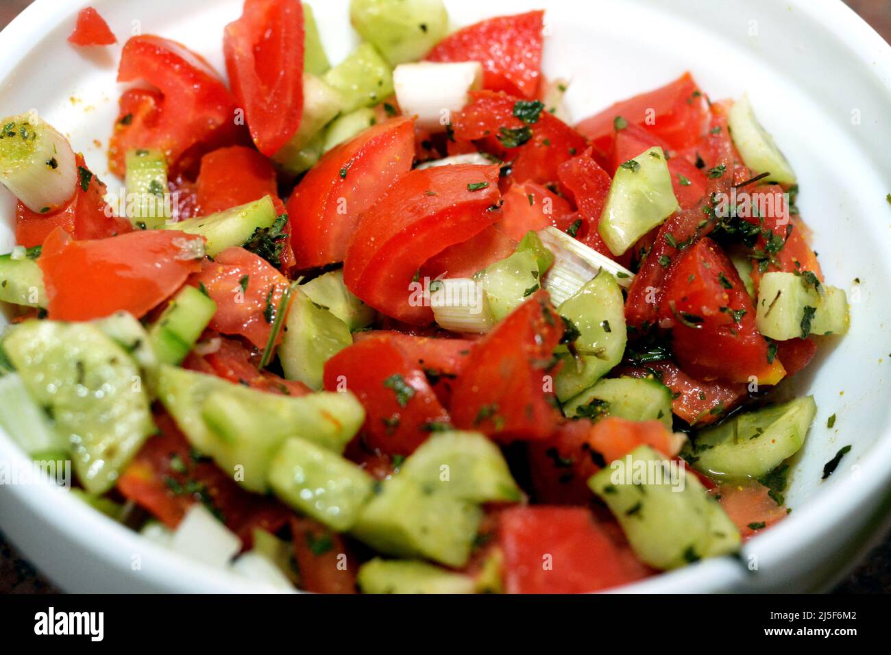 Traditional Arabic green salad with slices of cucumber, tomatoes and ...