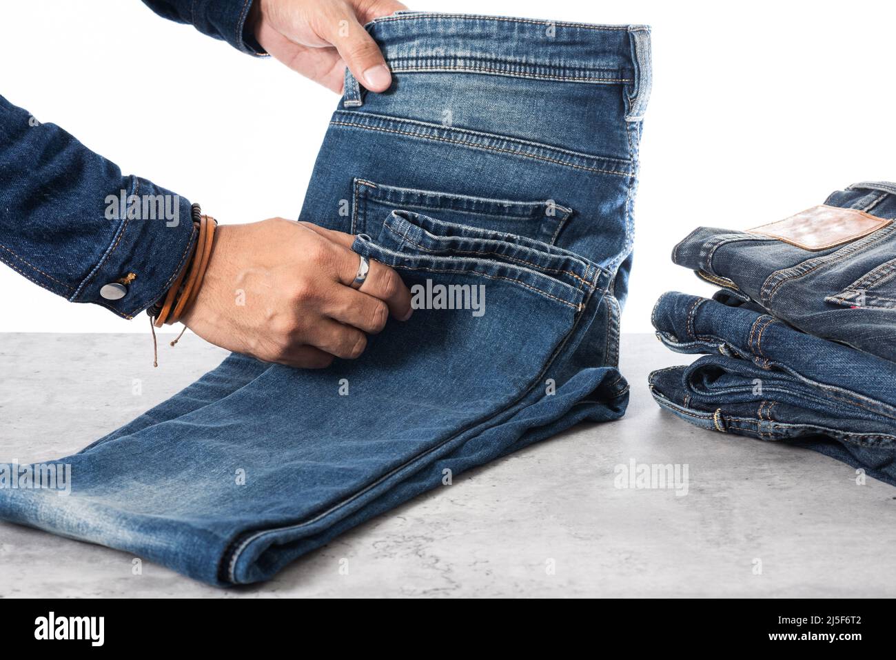 closeup blue jeans in man hand over white background Stock Photo - Alamy