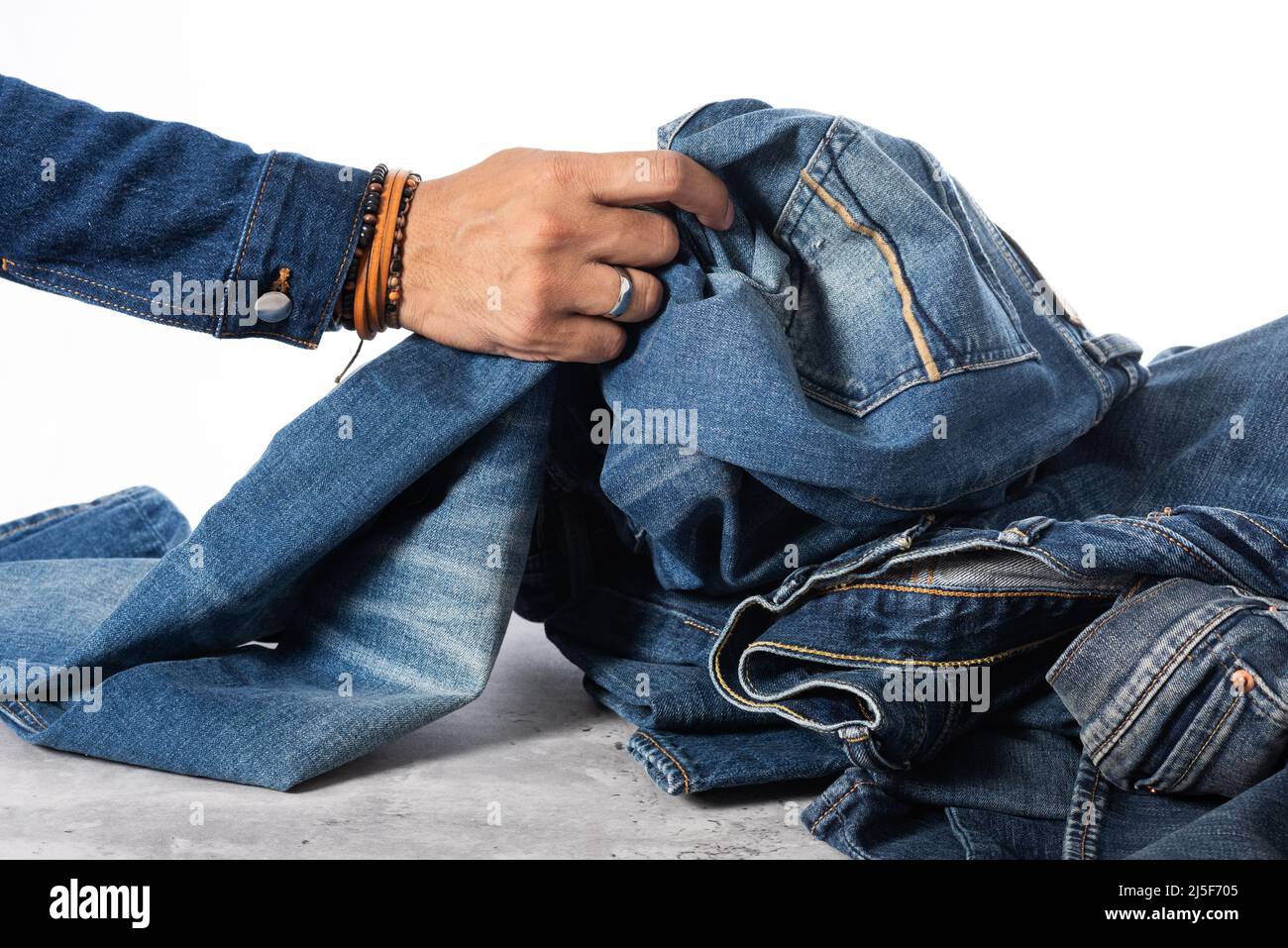 closeup blue jeans in man hand over white background Stock Photo - Alamy