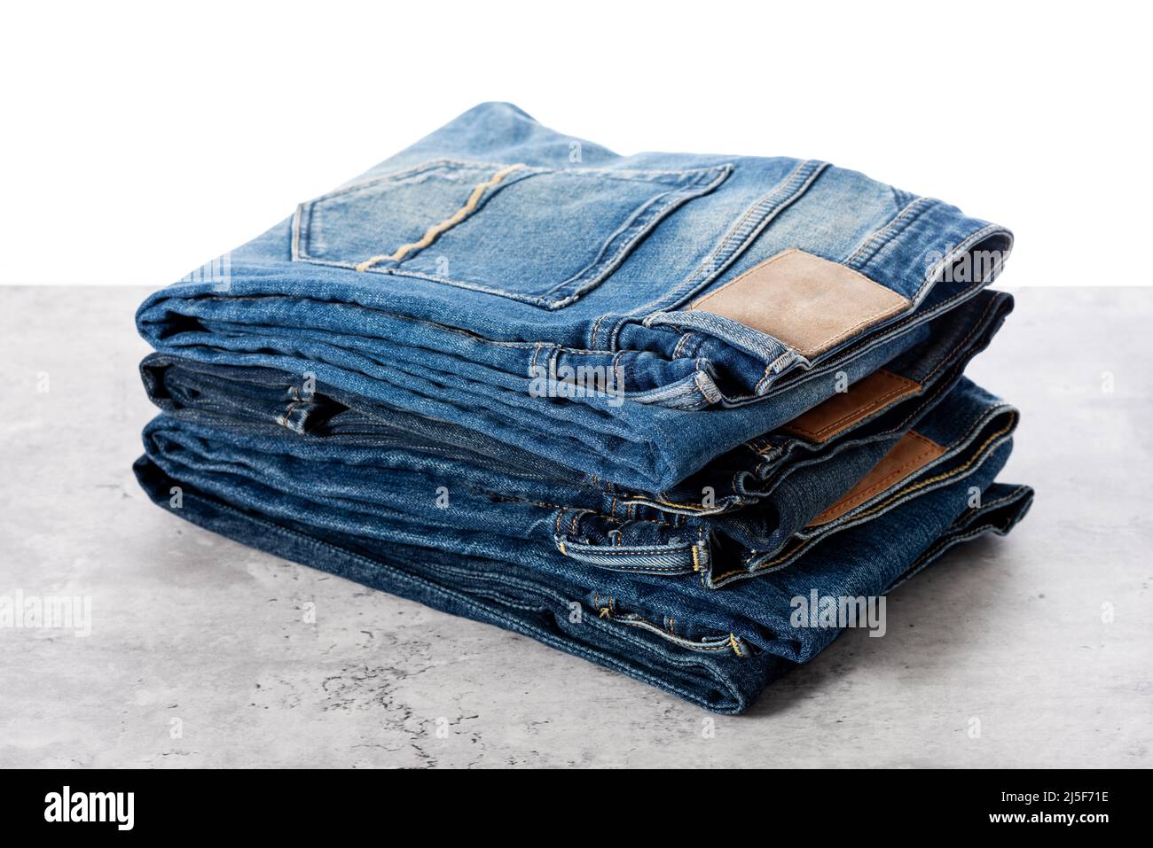 many blue jeans. men fashion denim jeans stacked over white background ...