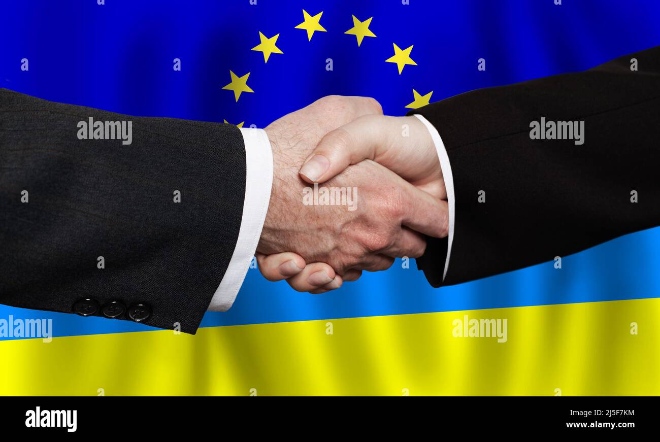 Handshake against European Union and Ukrainian flags background. Men ...