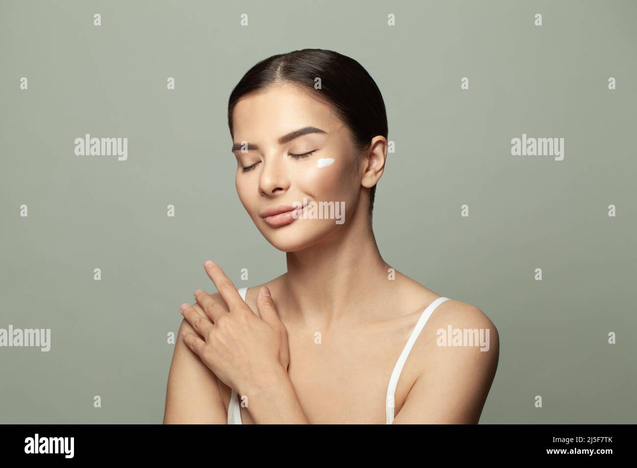 Pretty charming attractive woman touching, enjoying her perfect skin ...