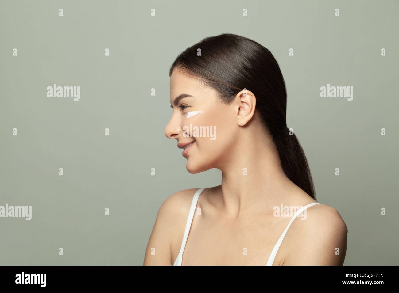 Beautiful profile of young healthy woman with moisture cream drops on ...
