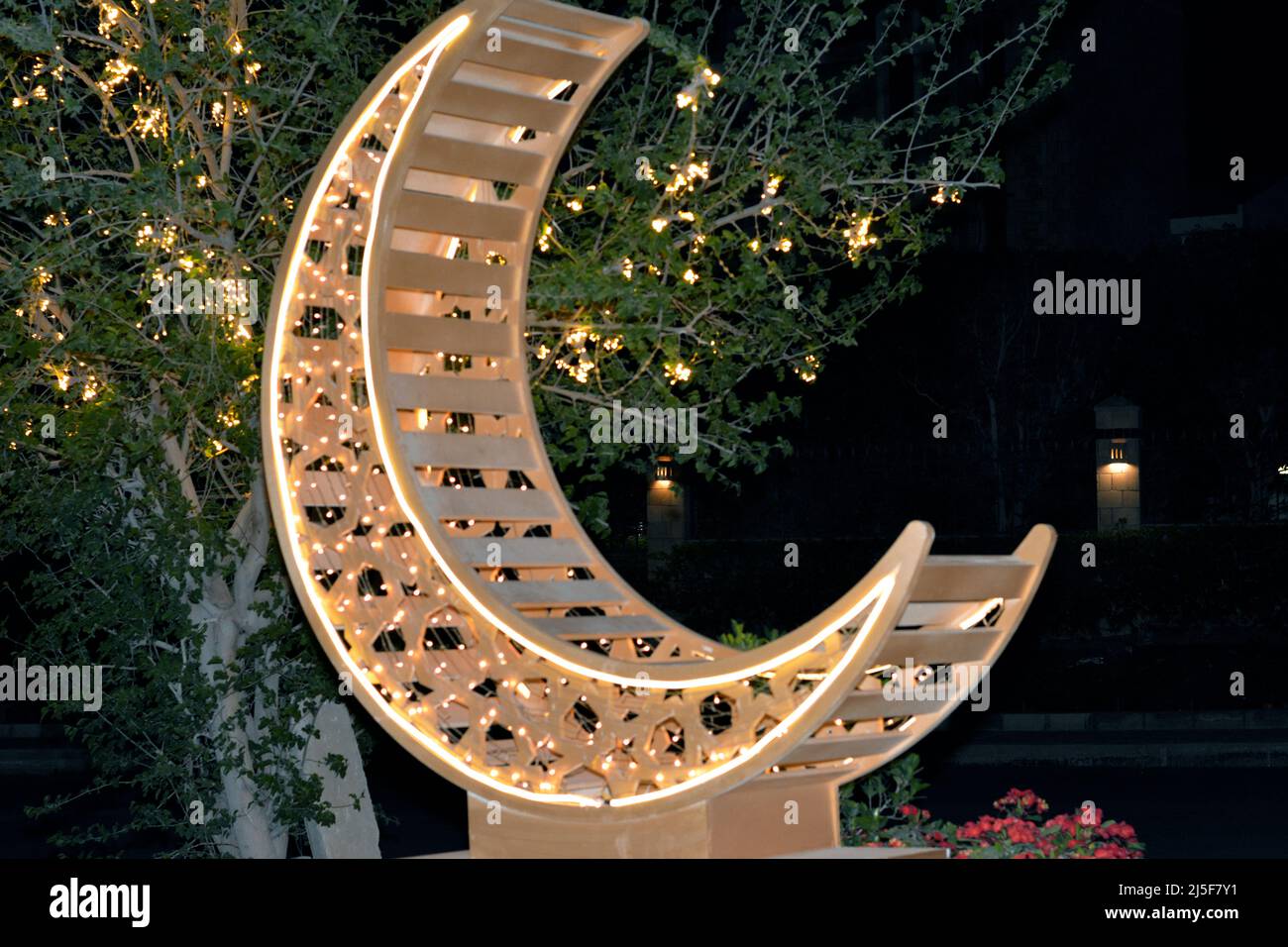 A wooden crescent that is decorated with led lights and other lights ...