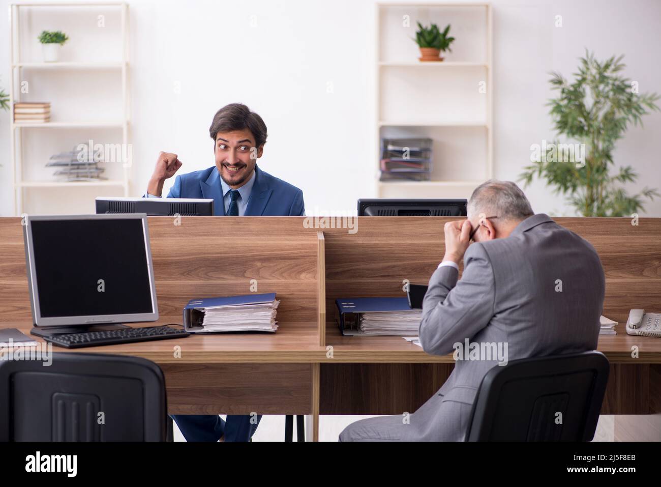 Two male employees working at workplace Stock Photo - Alamy