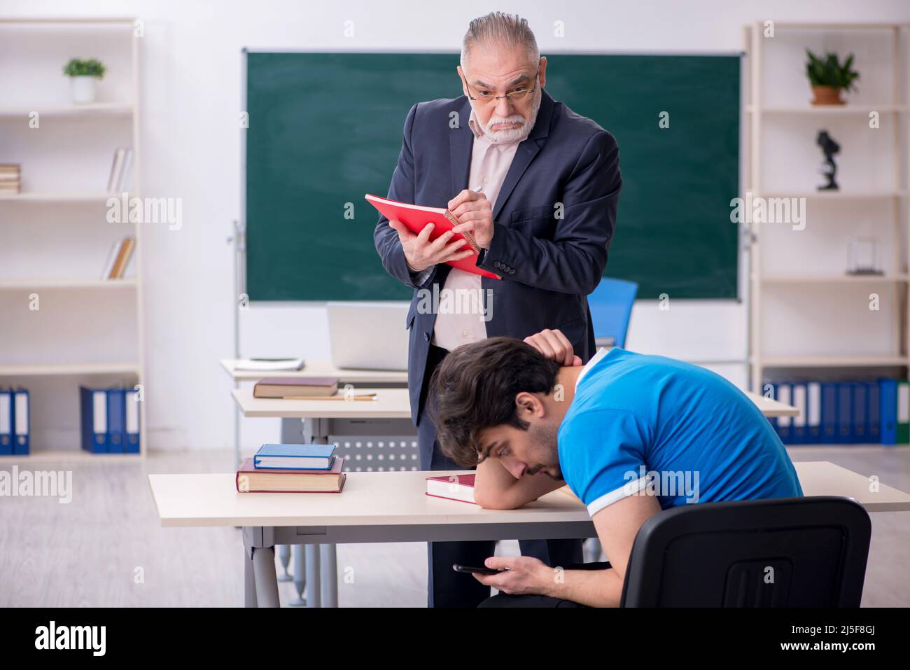 Old teacher and young phone addicted student in the classroom Stock ...
