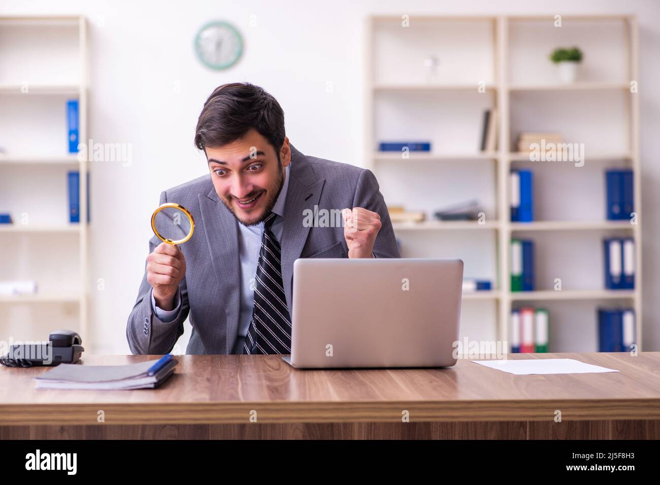 Young male auditor employee working in the office Stock Photo - Alamy