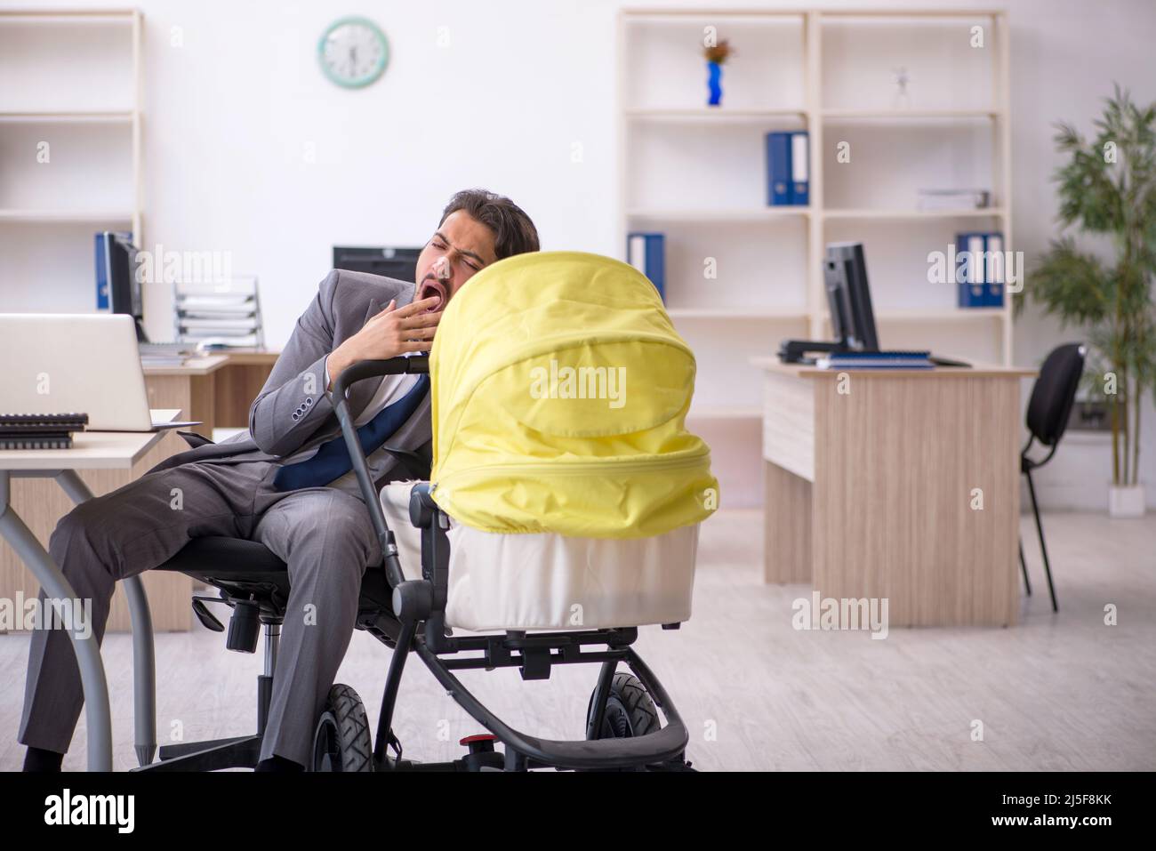Young businessman employee looking after new born in the office Stock ...