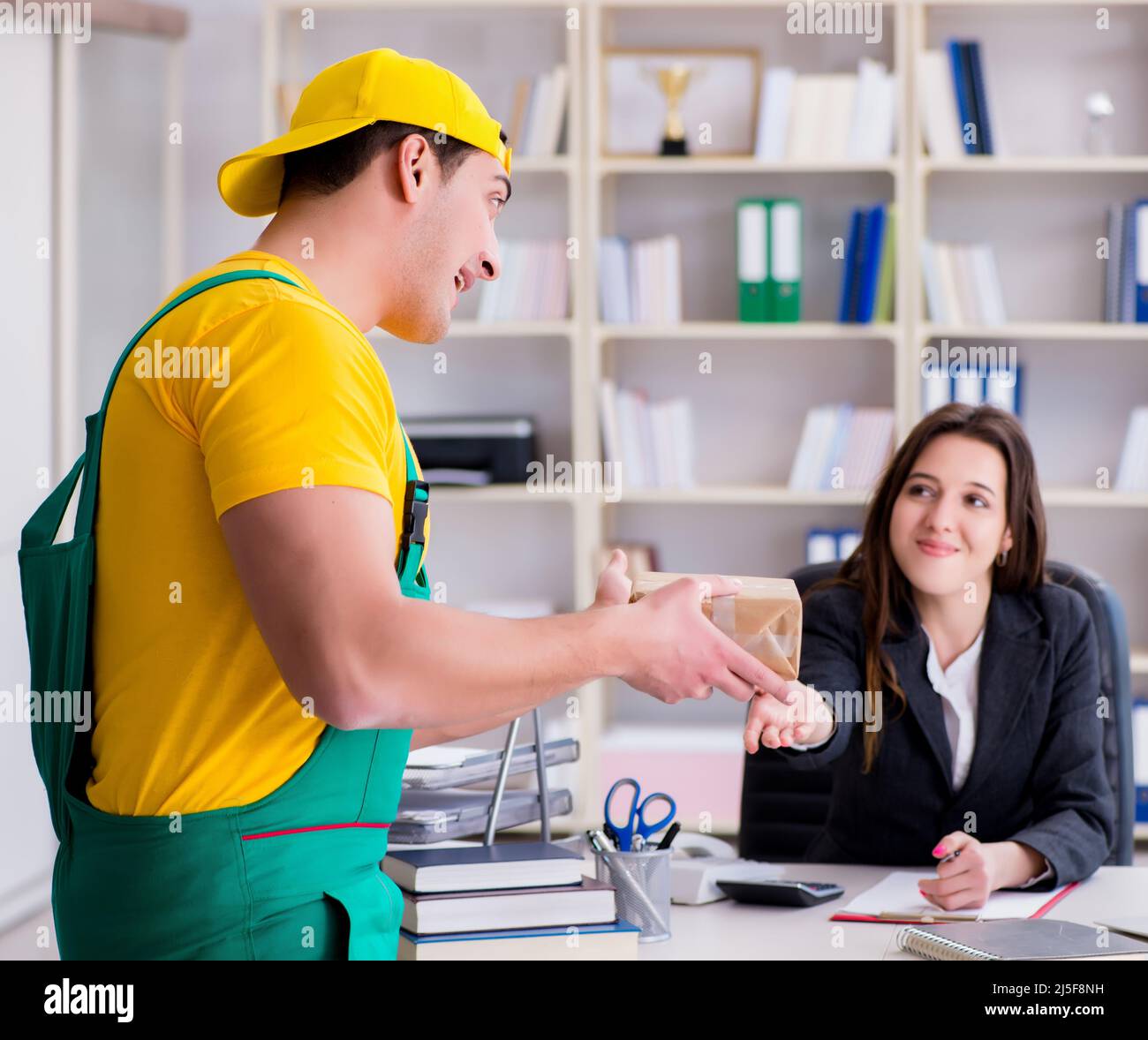The postman delivering parcel to the office Stock Photo - Alamy