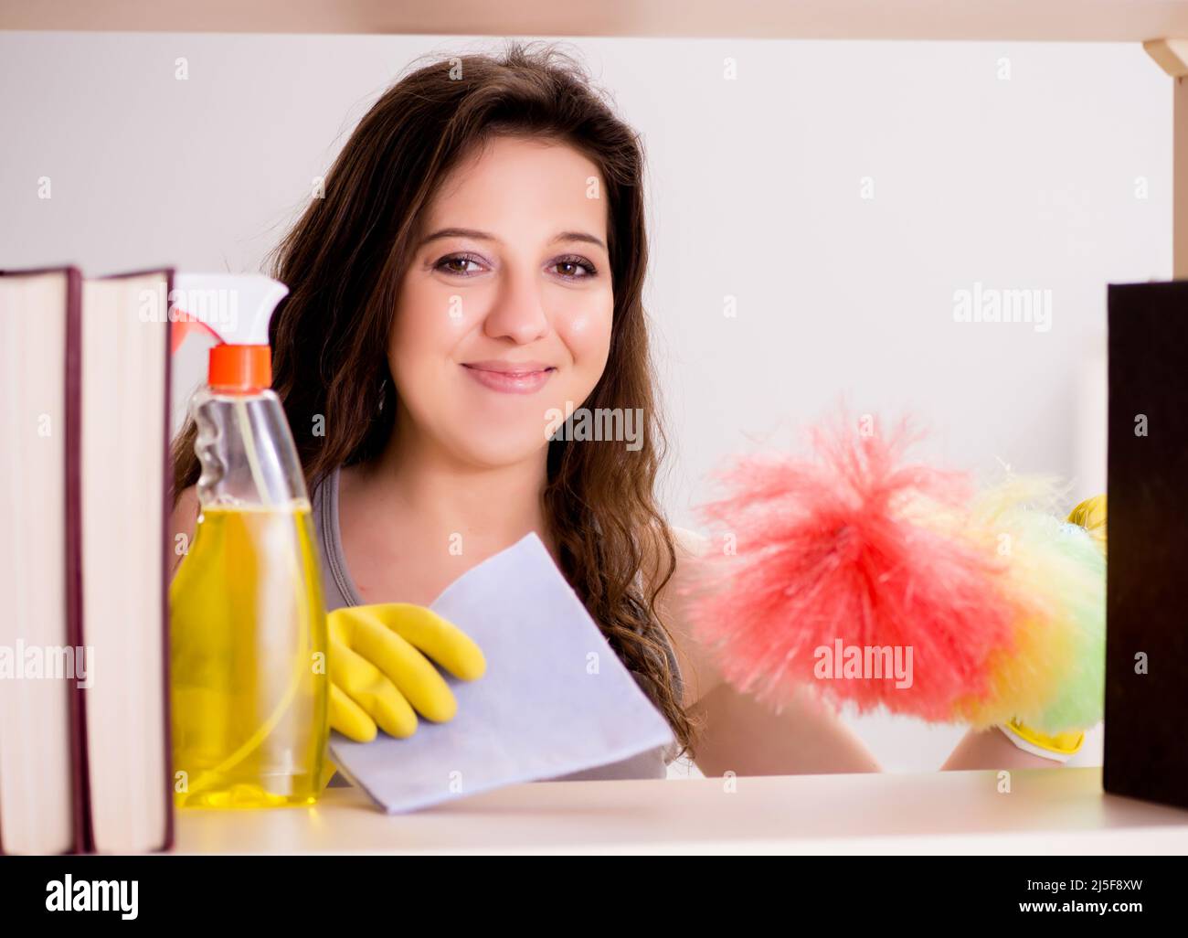 The woman cleaning dust from bookshelf Stock Photo - Alamy