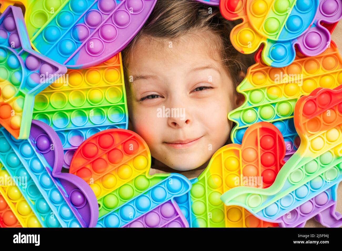 Little girl,kid,child head among many,lots of colorful pop it. Children ...