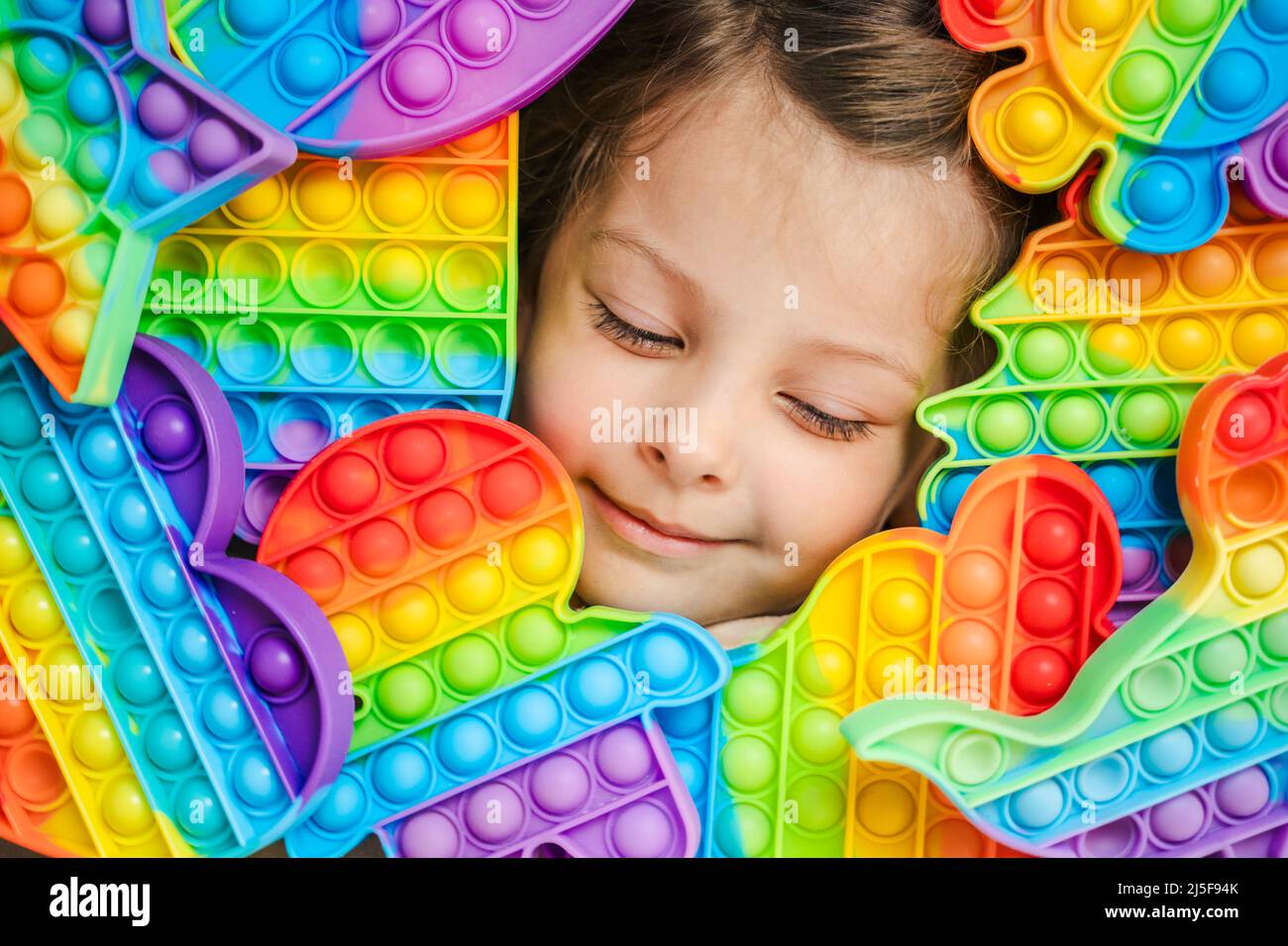 Little girl,kid,child head among many,lots of colorful pop it. Children ...
