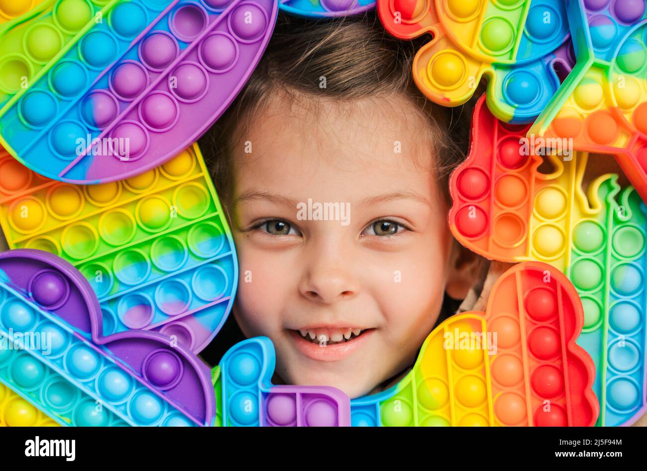 Little girl,kid,child head among many,lots of colorful pop it. Children ...