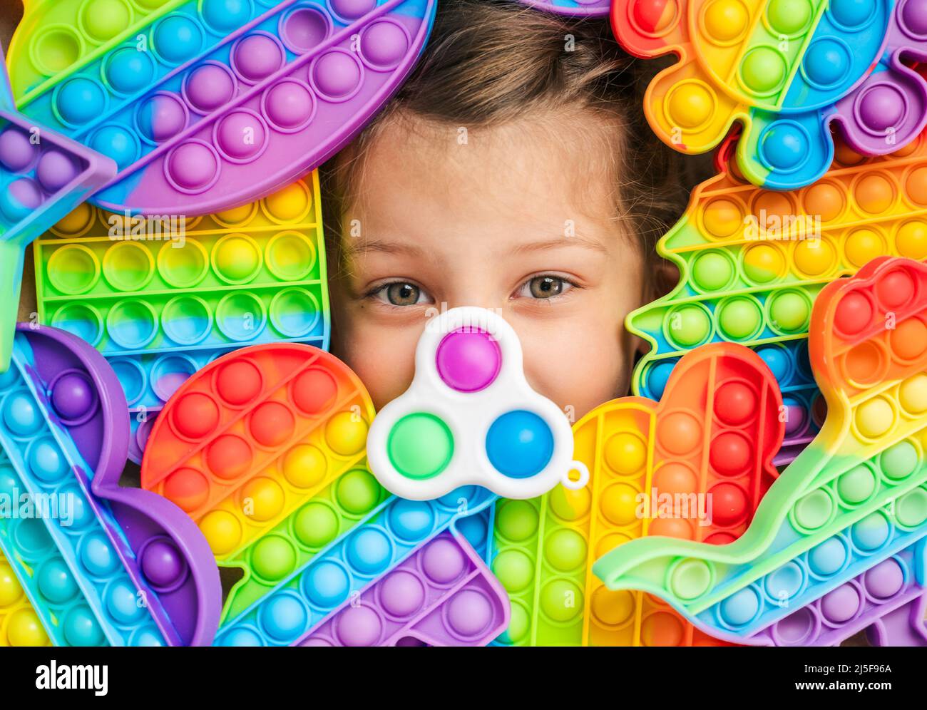 Little girl,kid,child head among many,lots of colorful pop it. Children ...