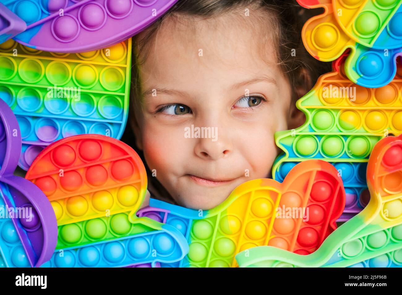 Little girl,kid,child head among many,lots of colorful pop it. Children ...