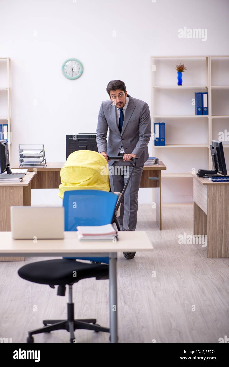 Young businessman employee looking after new born in the office Stock ...