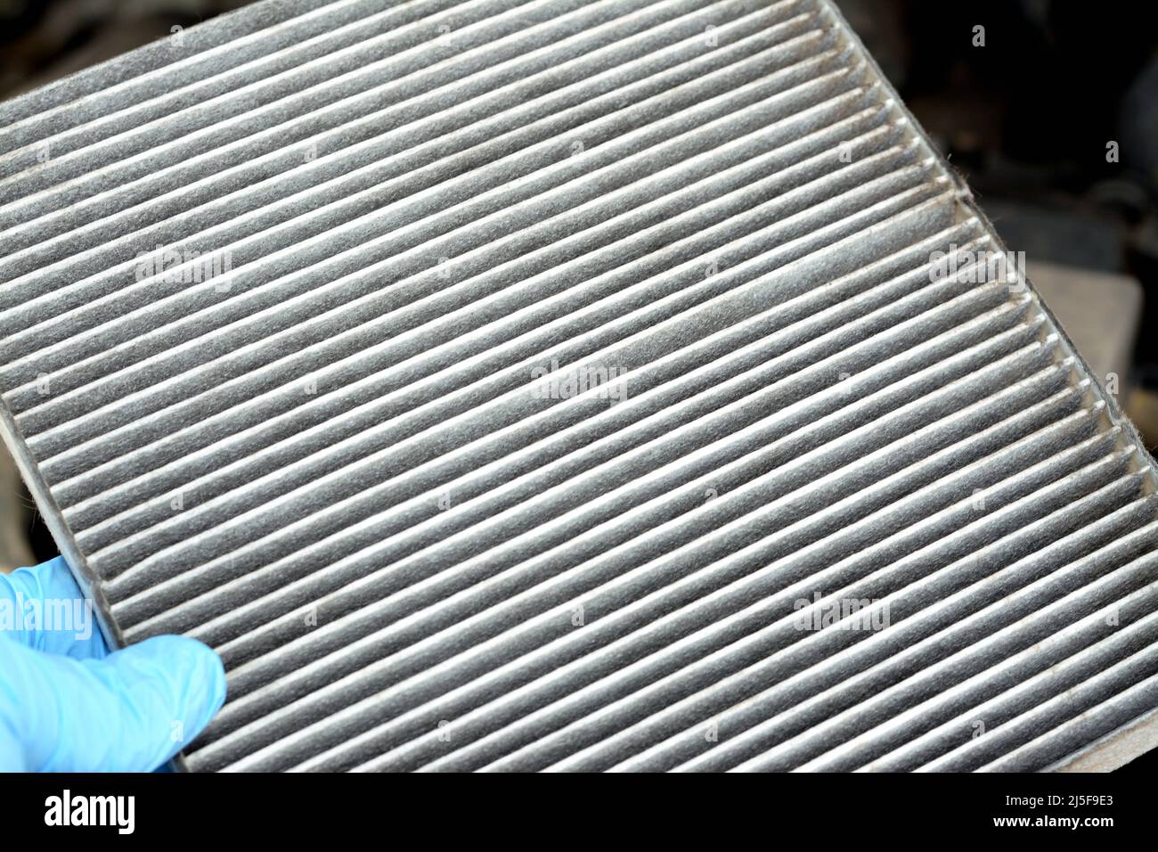 A closeup of an old dirty used car AC air conditioning filter full of ...