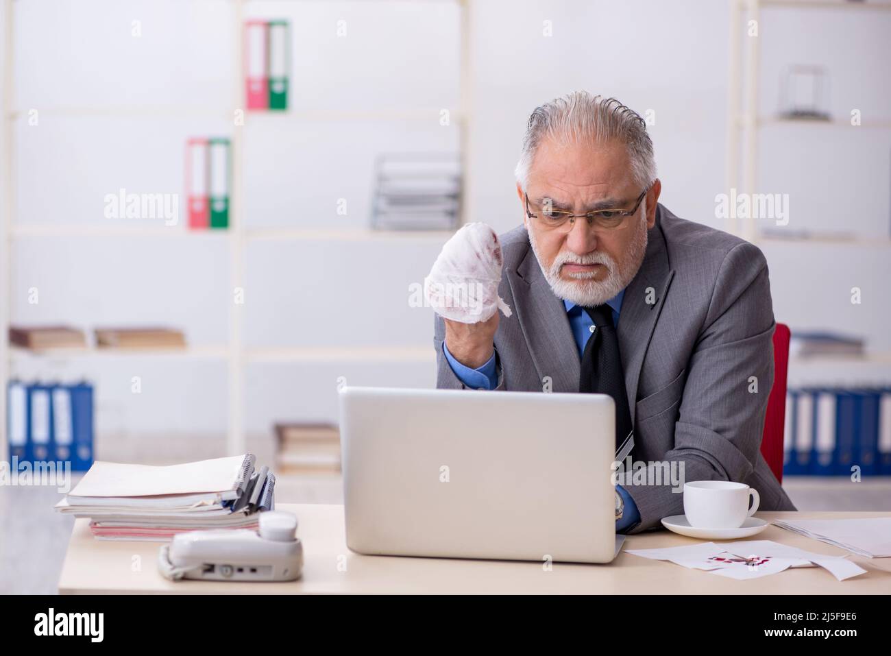 Old businessman employee cutting his hand at workplace Stock Photo - Alamy